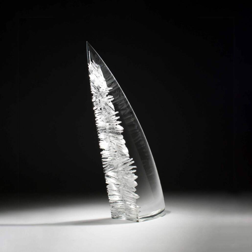 leaning glass sculpture reaching up to a fine point with crisp carving